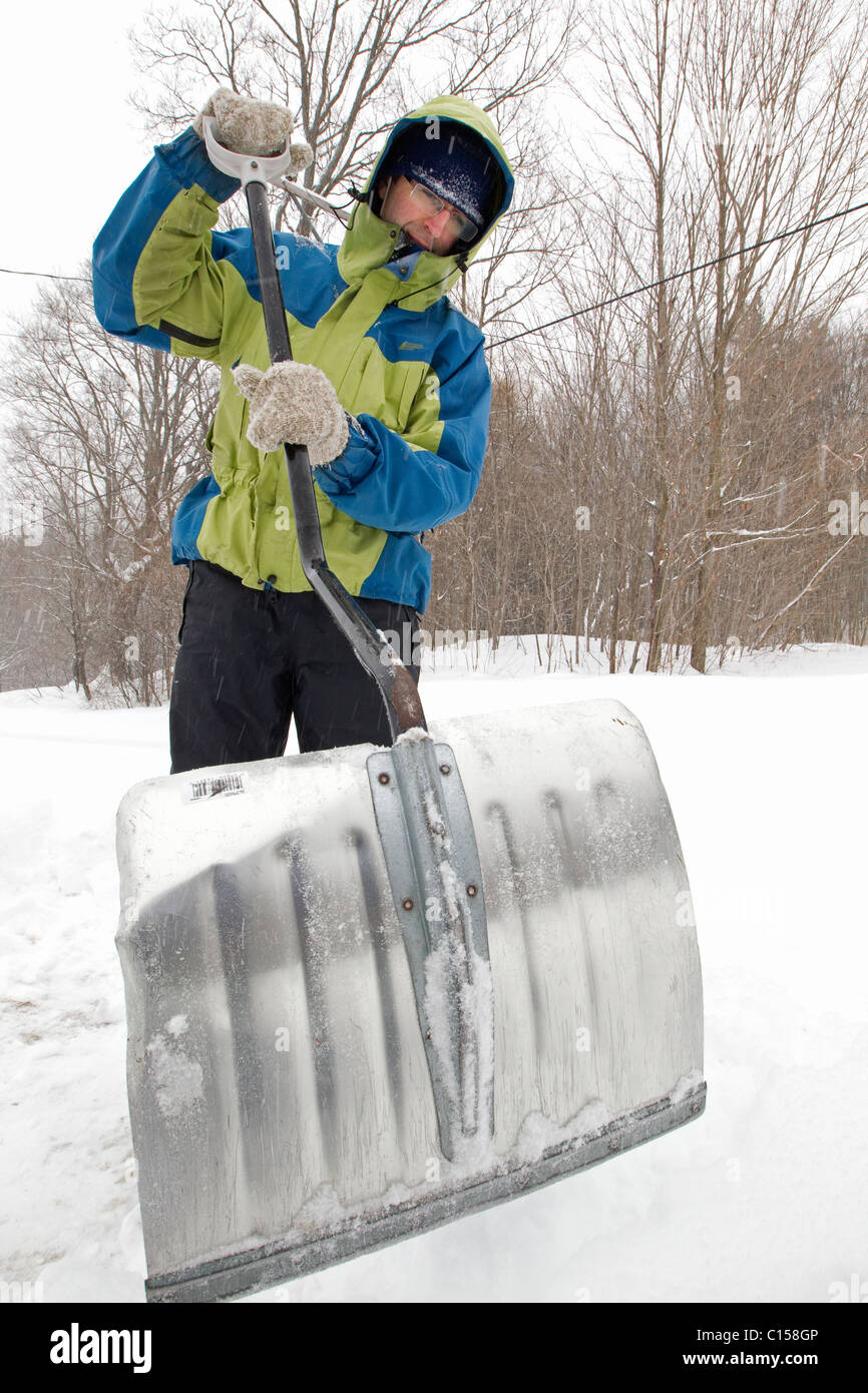 Man shoveling snow in winter Stock Photo - Alamy