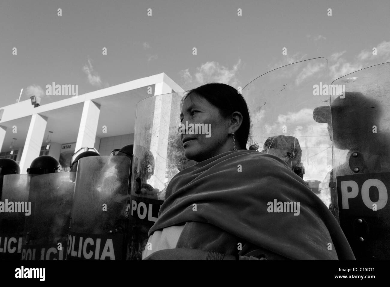 An Indian woman stands in front of the riot police block during the ...