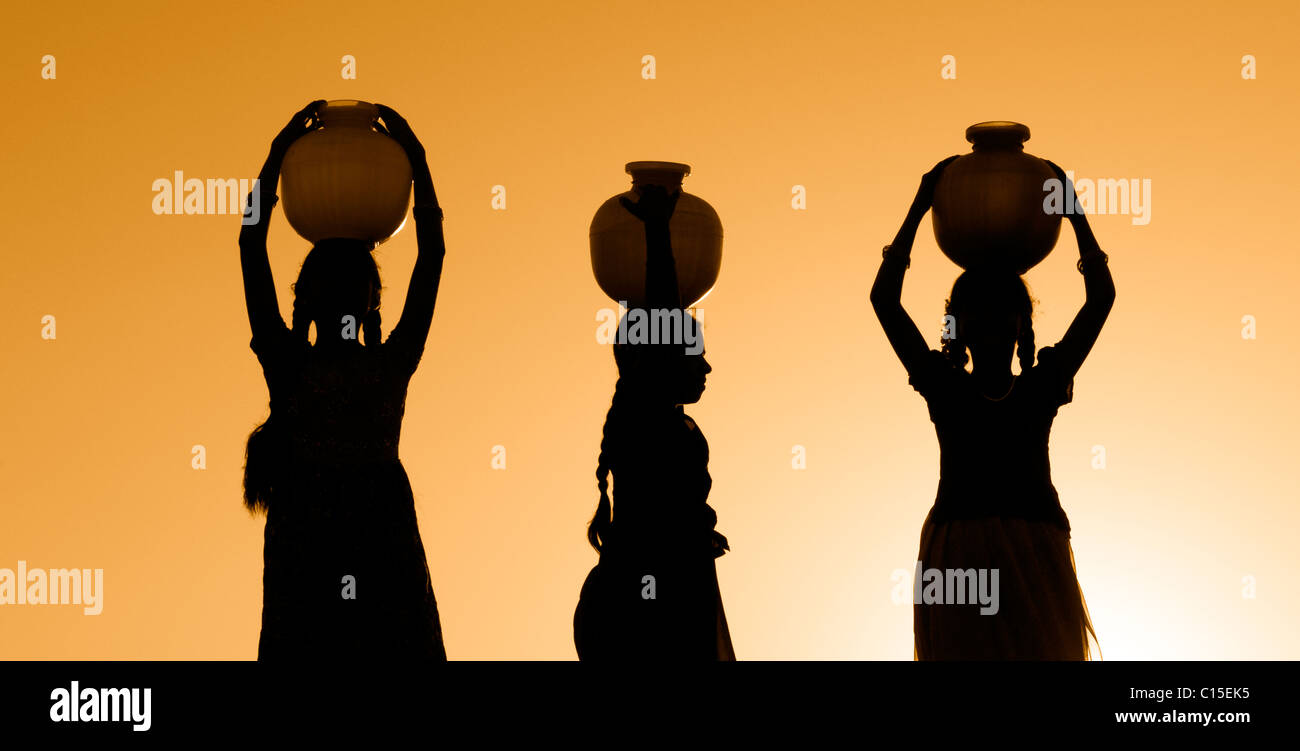 Rural Indian village girls balancing a water pot on their heads at ...