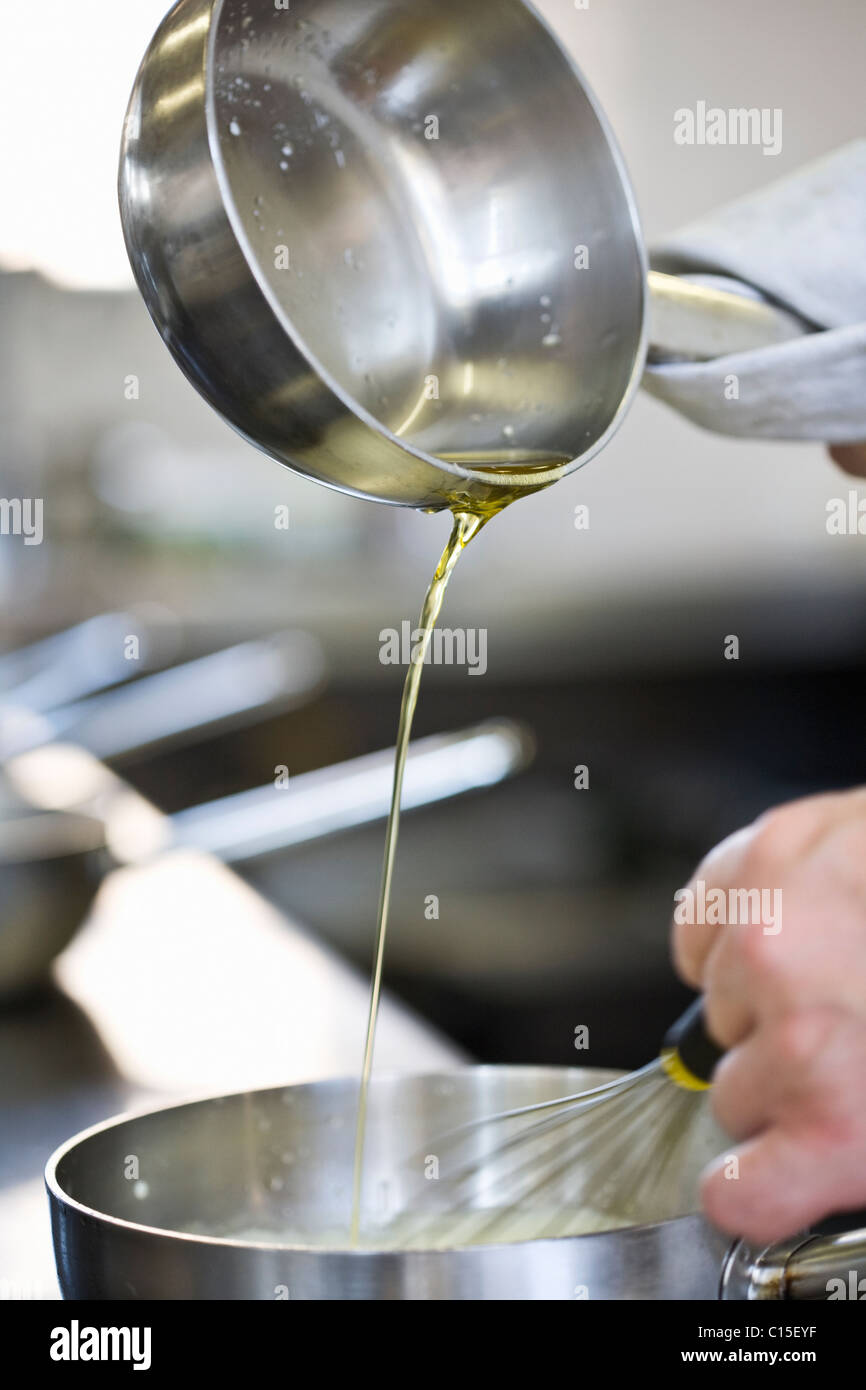 A chef pouring fish stock into a pan Stock Photo - Alamy