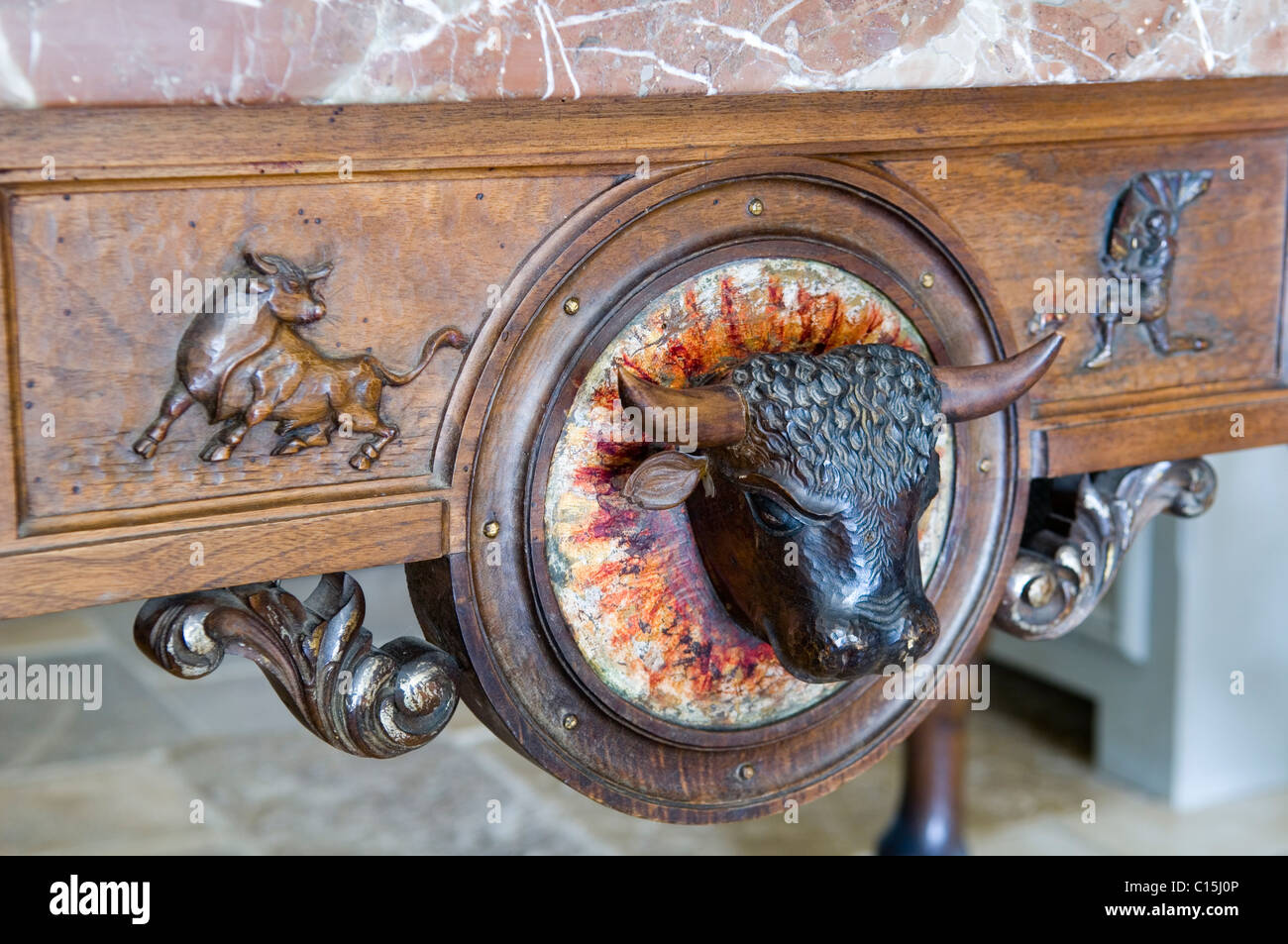 Detail of carved bull head on wooden table with marble top Stock Photo ...