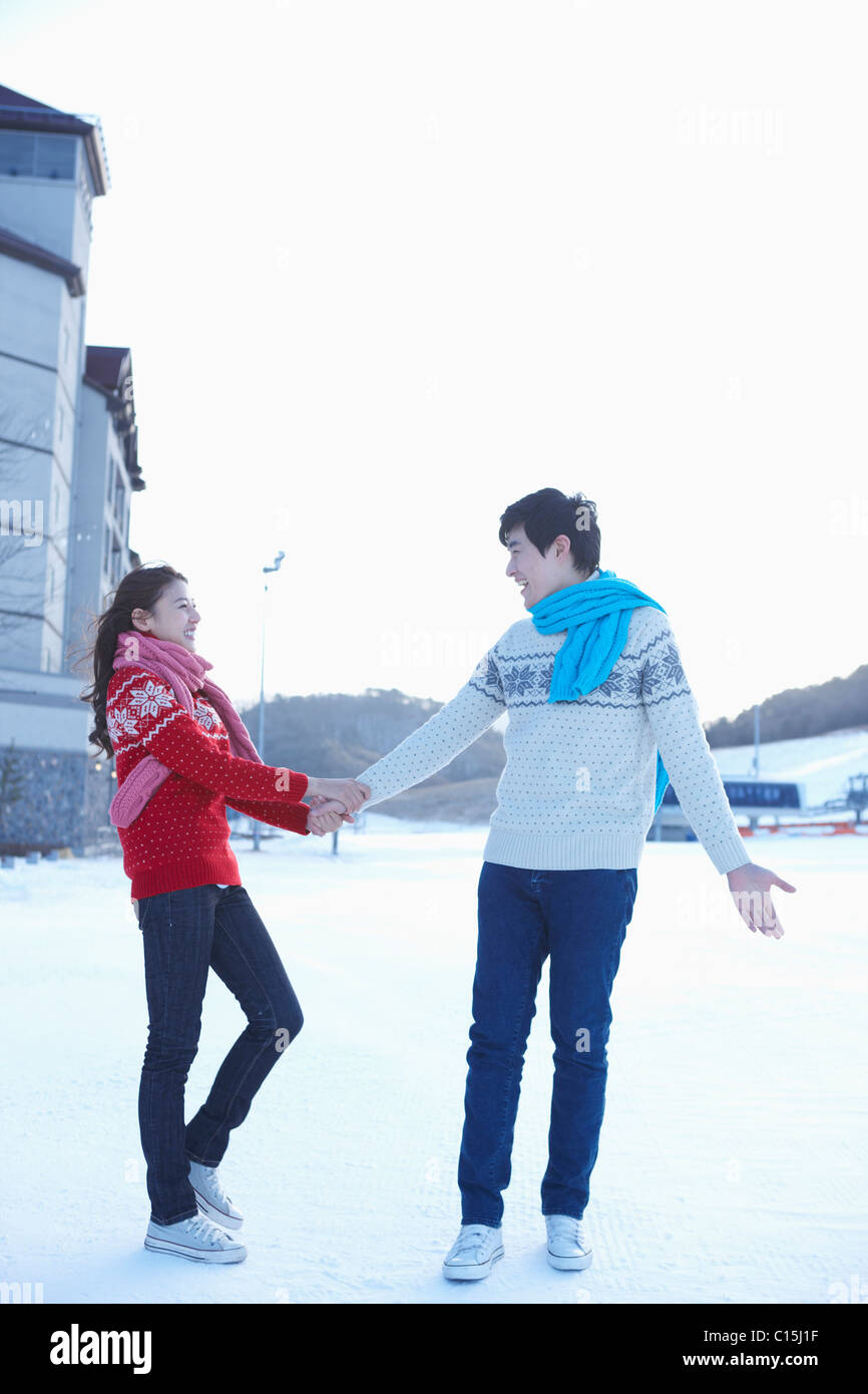 cordial couple holding hands in same clothing Stock Photo - Alamy