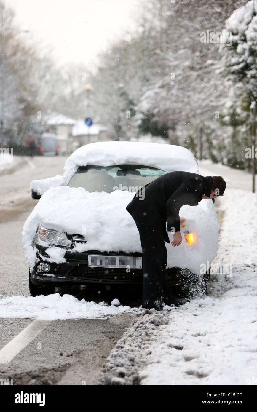 A motorist returns to his abandoned car, clearing off the massive build ...