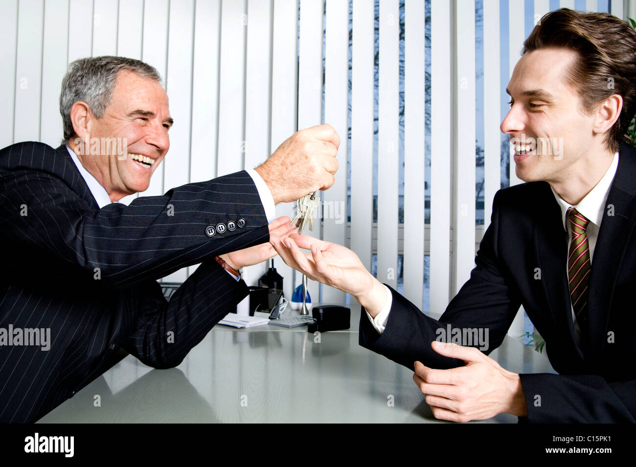 Businessman passing key Stock Photo - Alamy