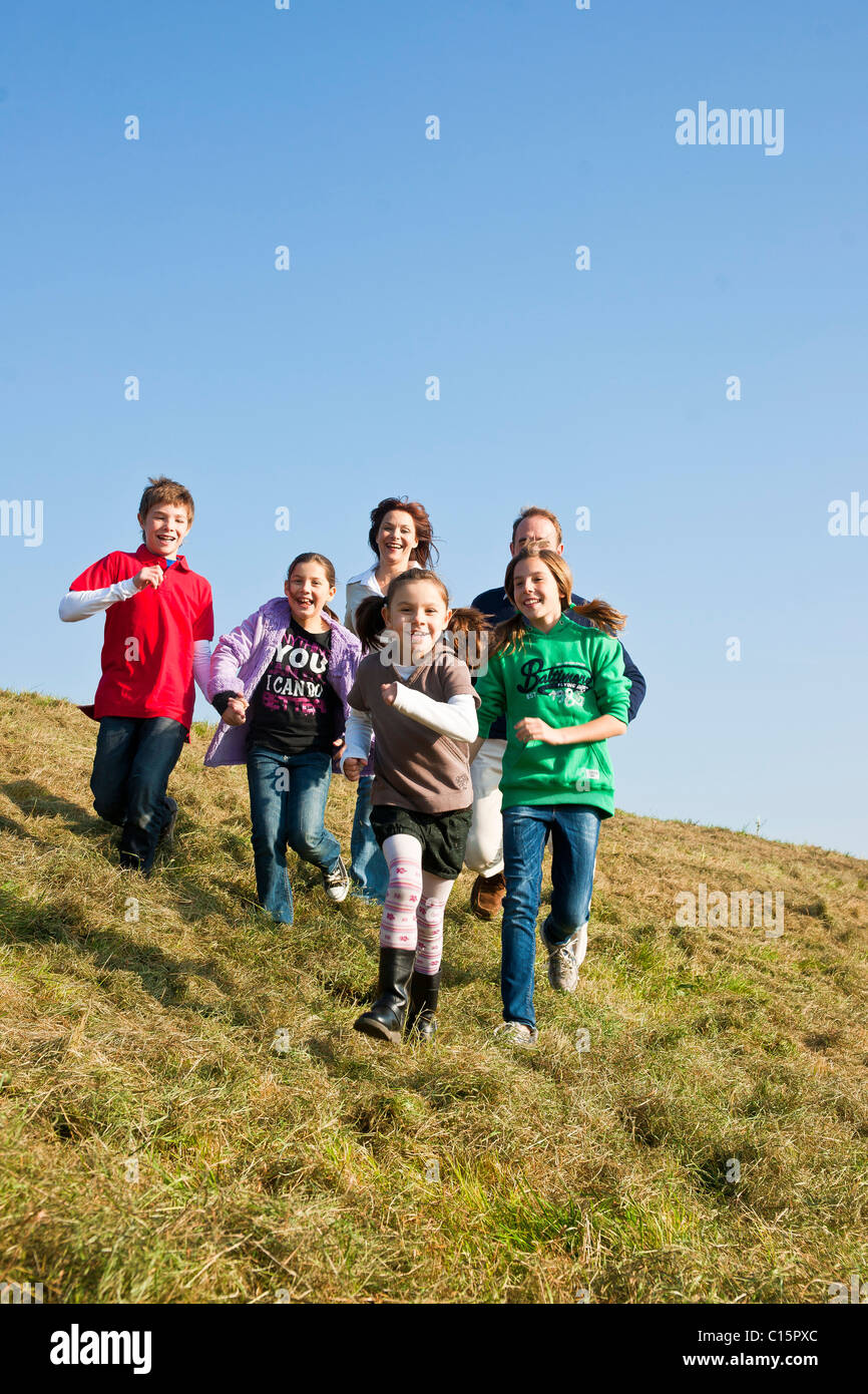 Family four kids running over meadow Stock Photo - Alamy