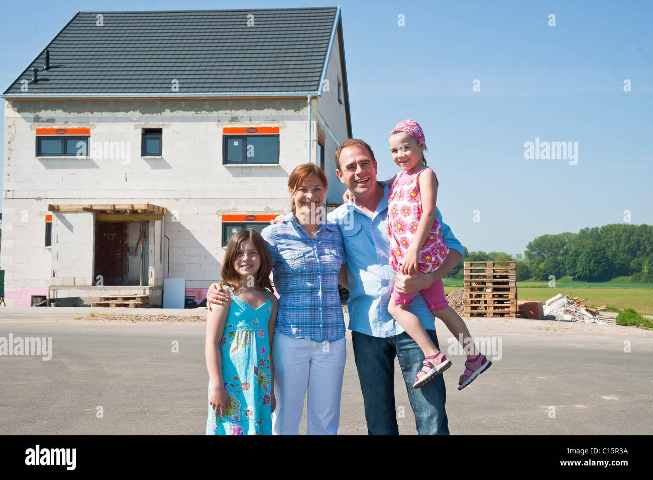 Family standing in front of shell of building Stock Photo - Alamy