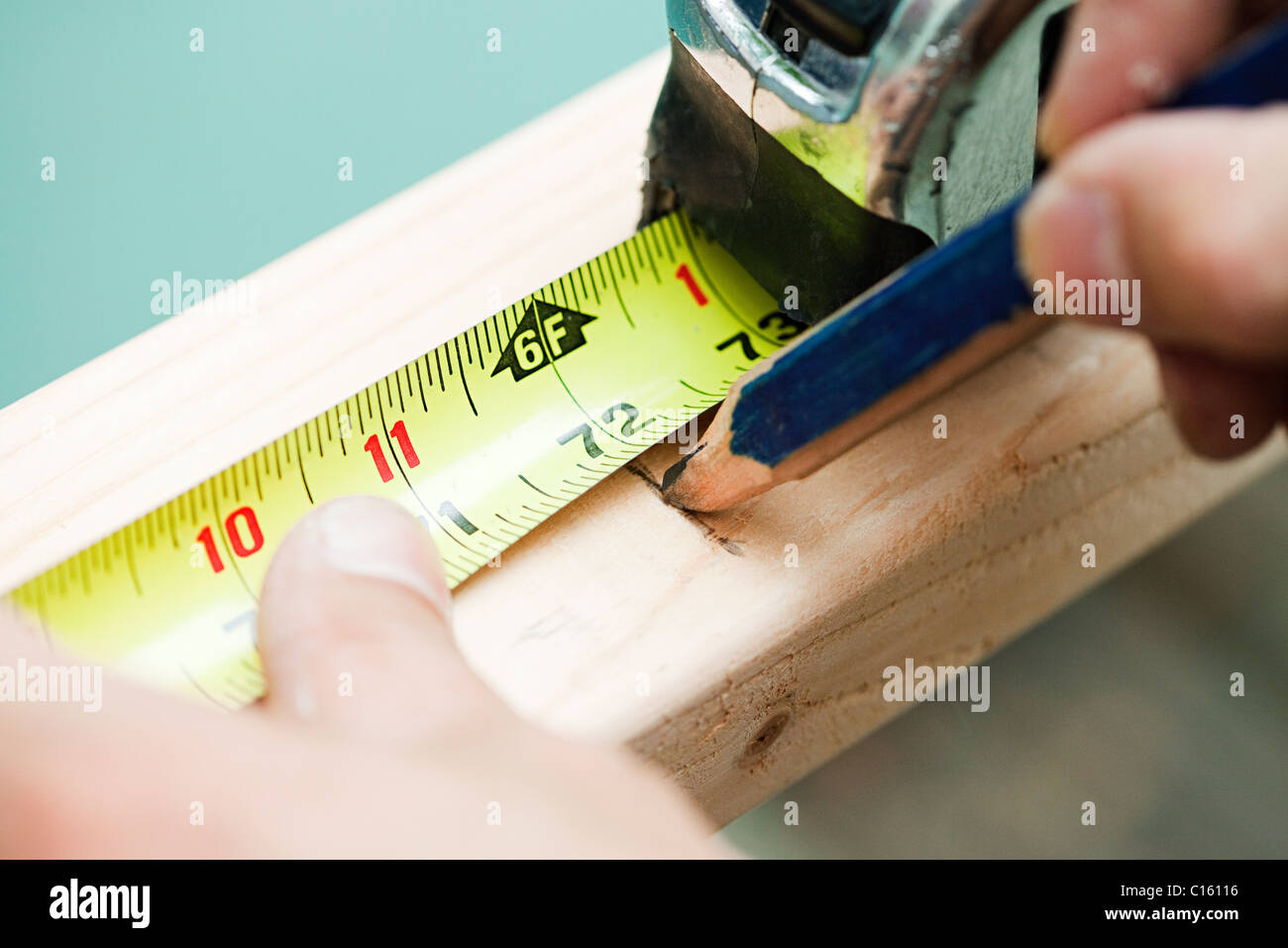 Woman measuring plank of wood and marking with pencil Stock Photo - Alamy