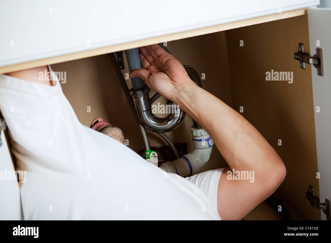 Plumber fixing sink Stock Photo - Alamy