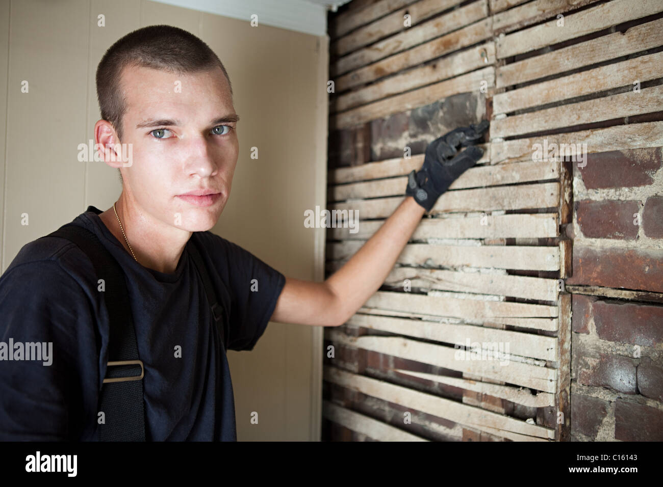 Young man touching exposed wall Stock Photo - Alamy