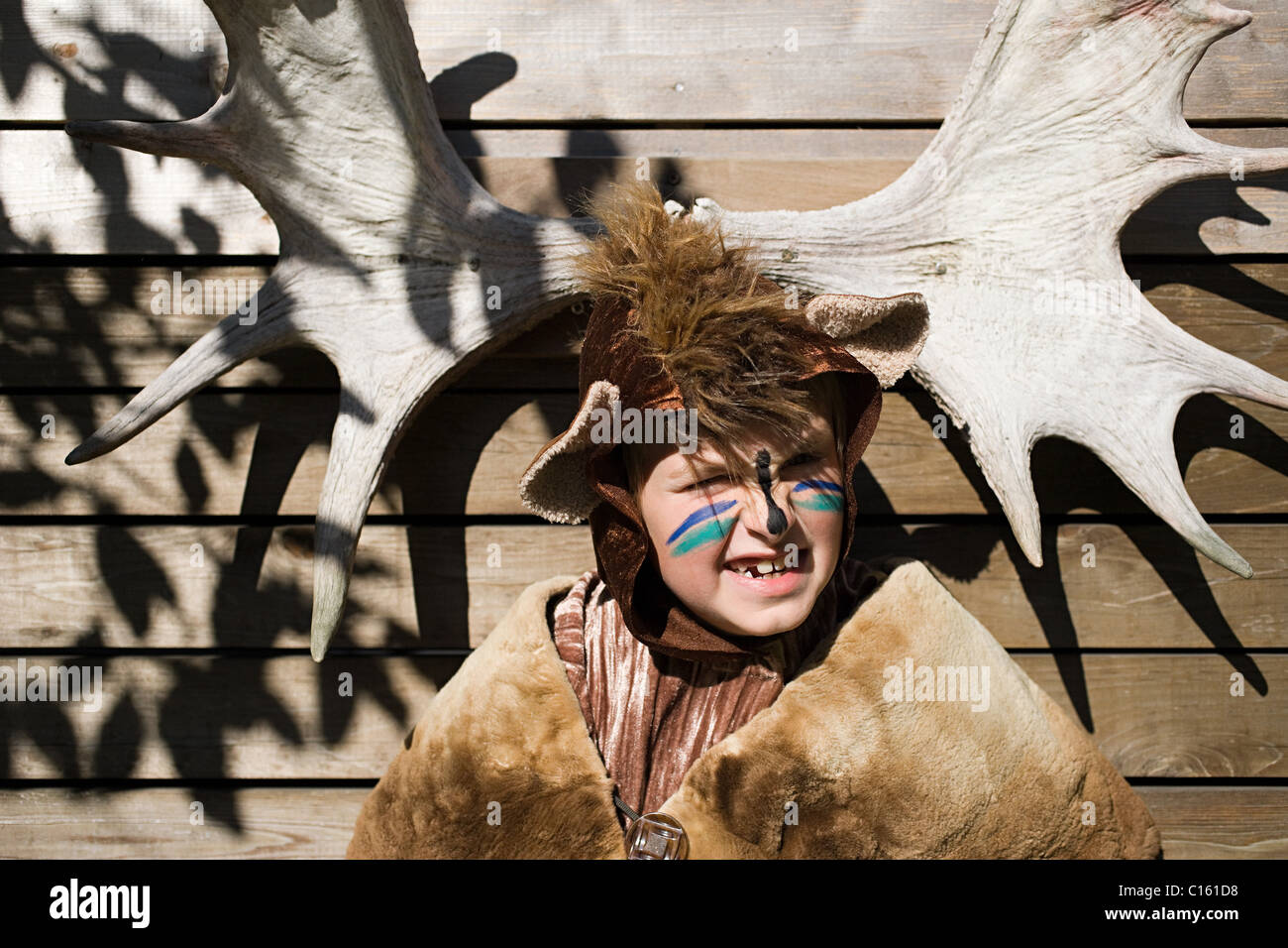 Boy dressed up as bear in front of moose antlers Stock Photo - Alamy