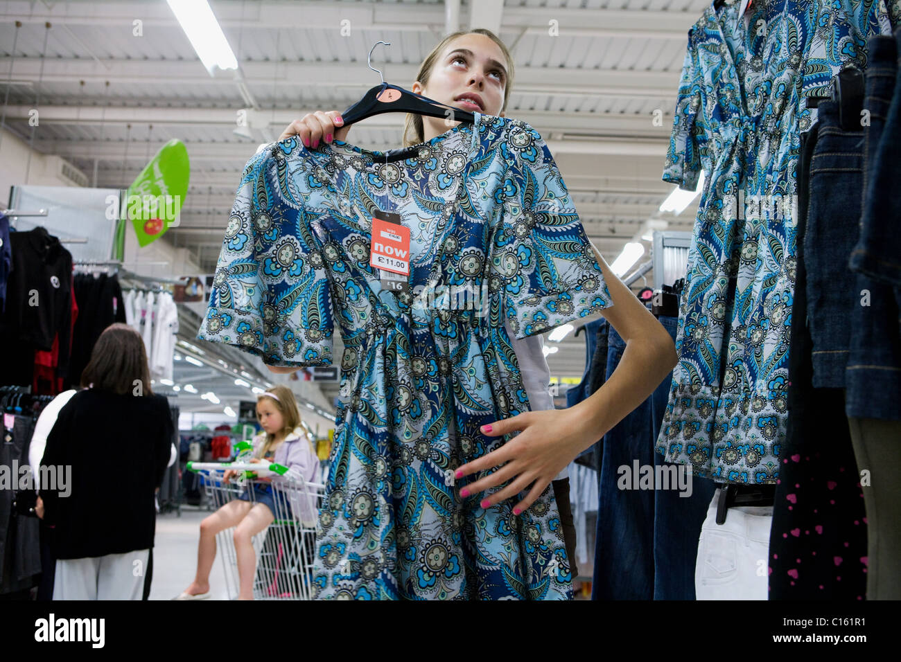 Teenage girl shopping for dress Stock Photo - Alamy