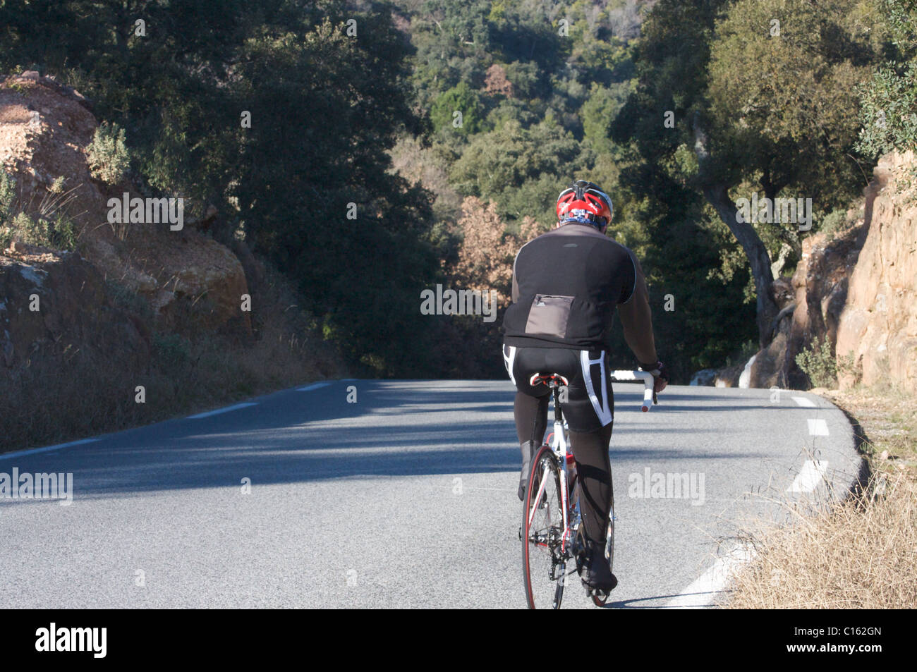 Senior cyclist at the top of a climbing road in Esterel, French Riviera ...