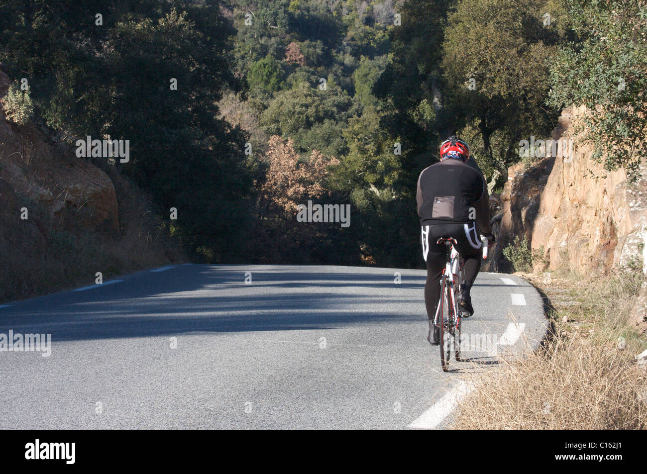 Senior cyclist at the top of a climbing road in Esterel, French Riviera ...