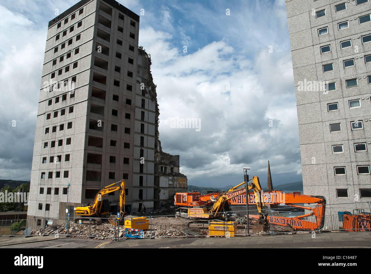 Derelict tower blocks of flats ready for demolition with machinery ...