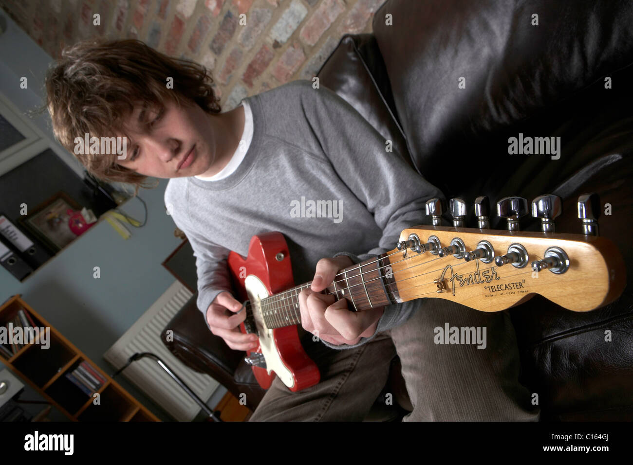 Teenage boy playing vintage red and white electric telecaster fender ...