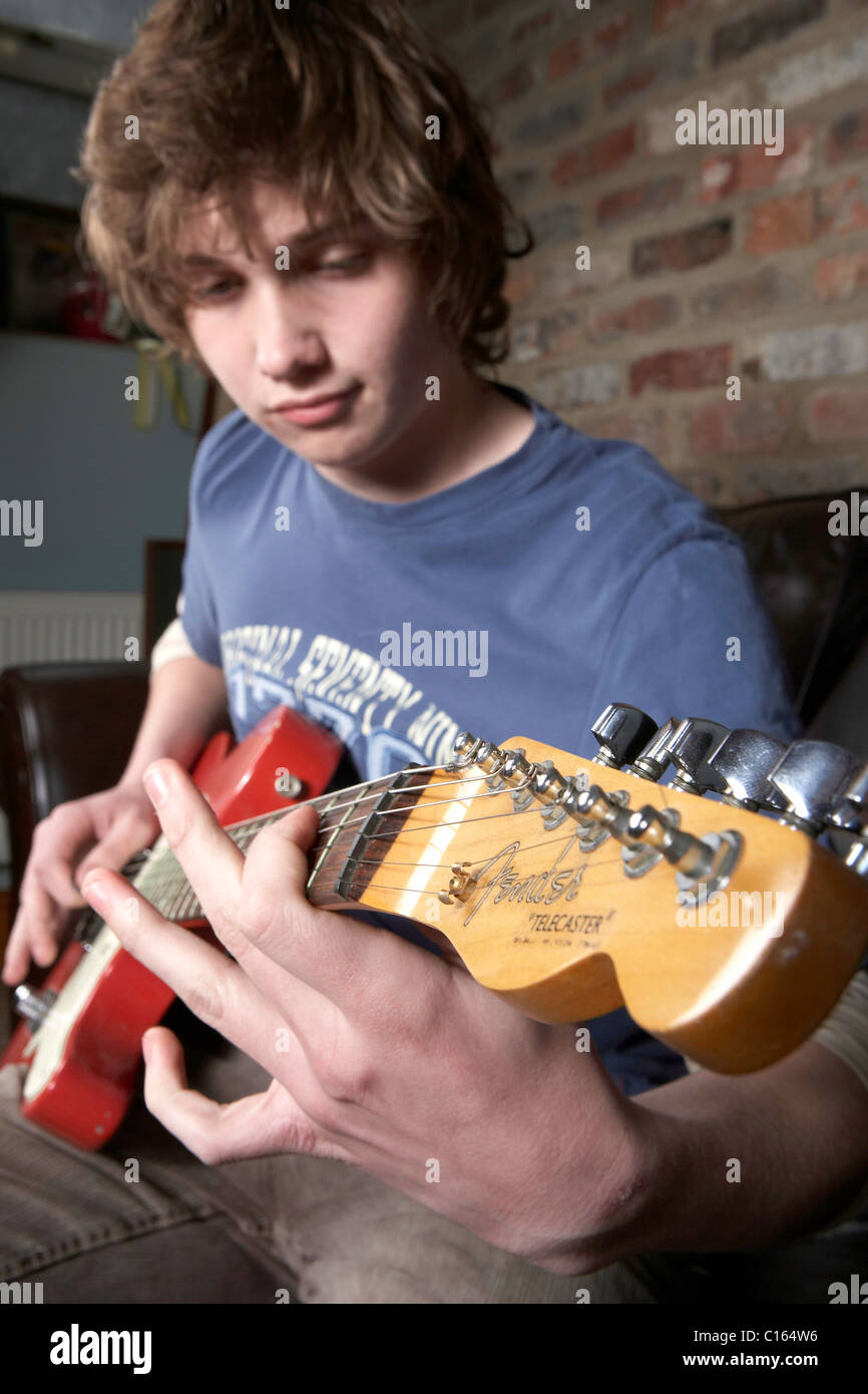 Teenage boy playing vintage red and white electric telecaster fender ...