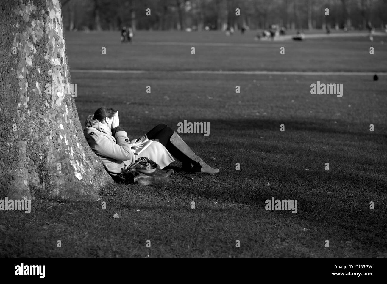 Woman sitting under tree reading Black and White Stock Photos & Images ...