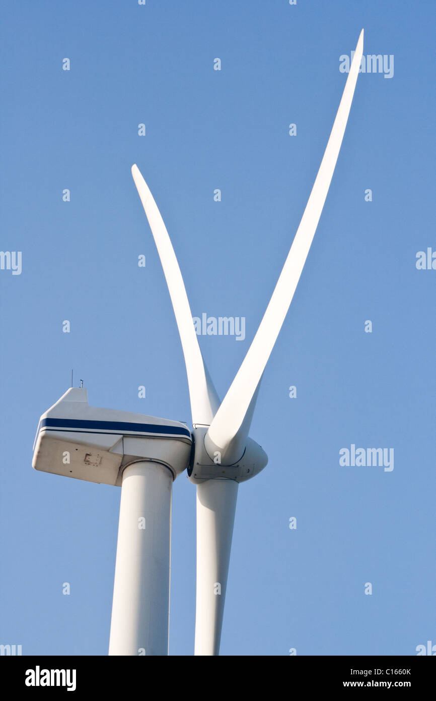 White wind turbine generating electricity on blue sky Stock Photo - Alamy