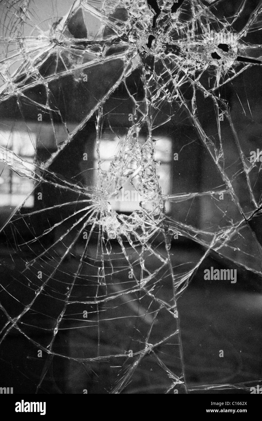 Broken pane of glass in a window with a room behind Stock Photo - Alamy