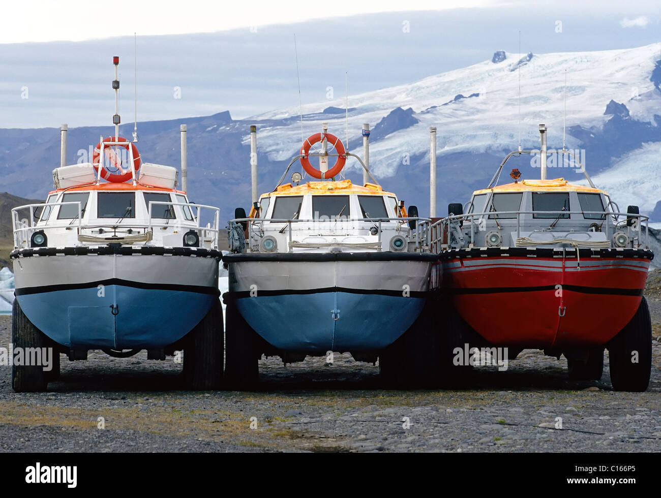 Three amphibious vehicles for excursions on a glacial lake, parked on ...