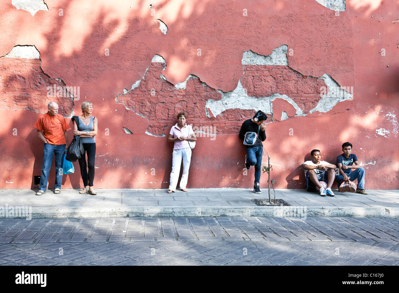 diverse group of people wait at bus stop against marvelous old ...