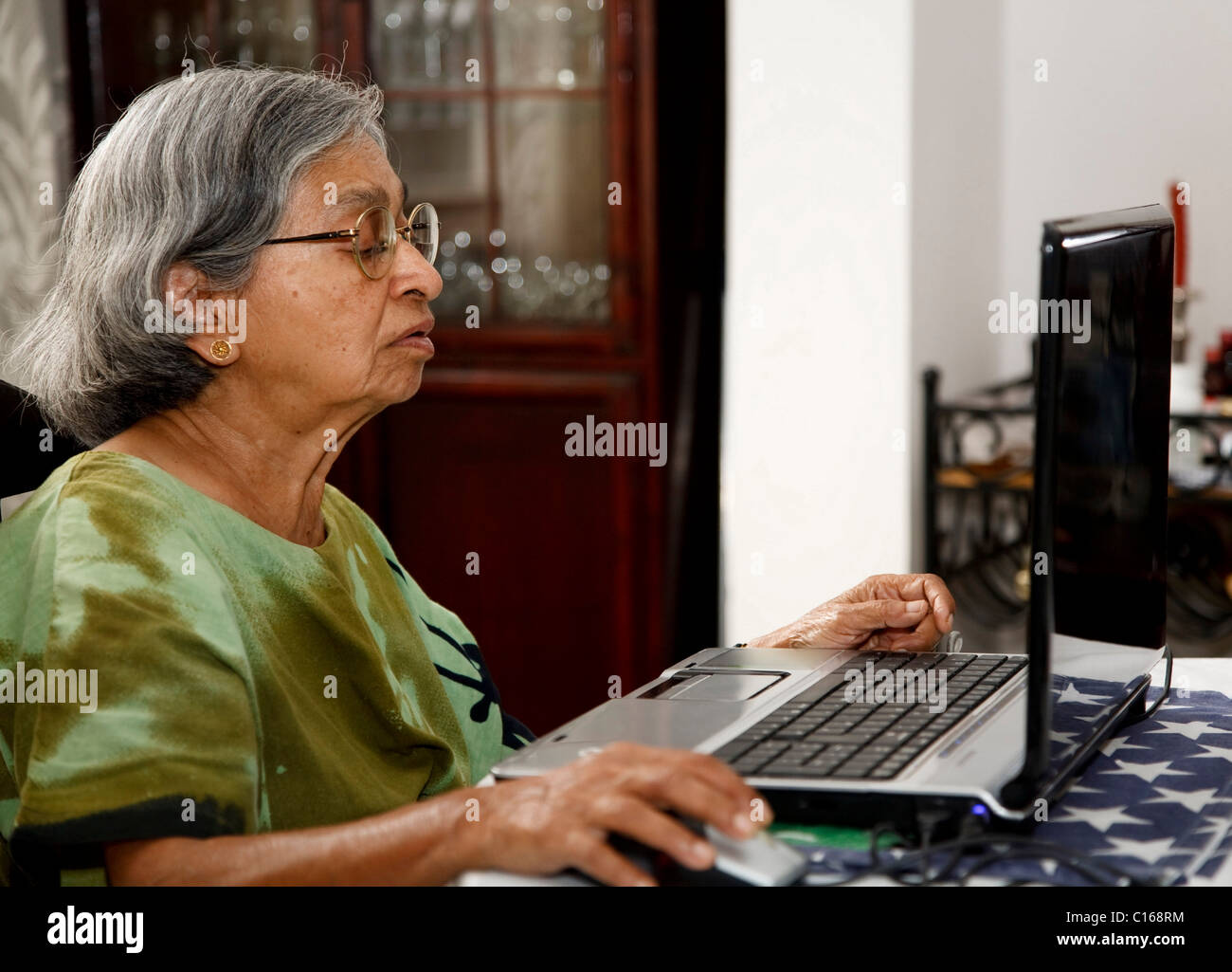 Elderly Asian Indian woman uses a laptop computer at home Stock Photo ...