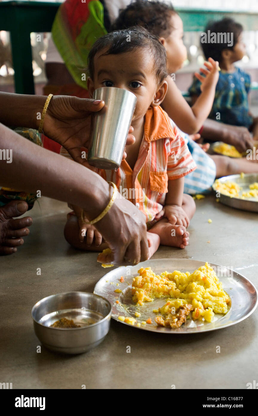 Feeding a malnourished infant with tuberculosis from the slums at ...