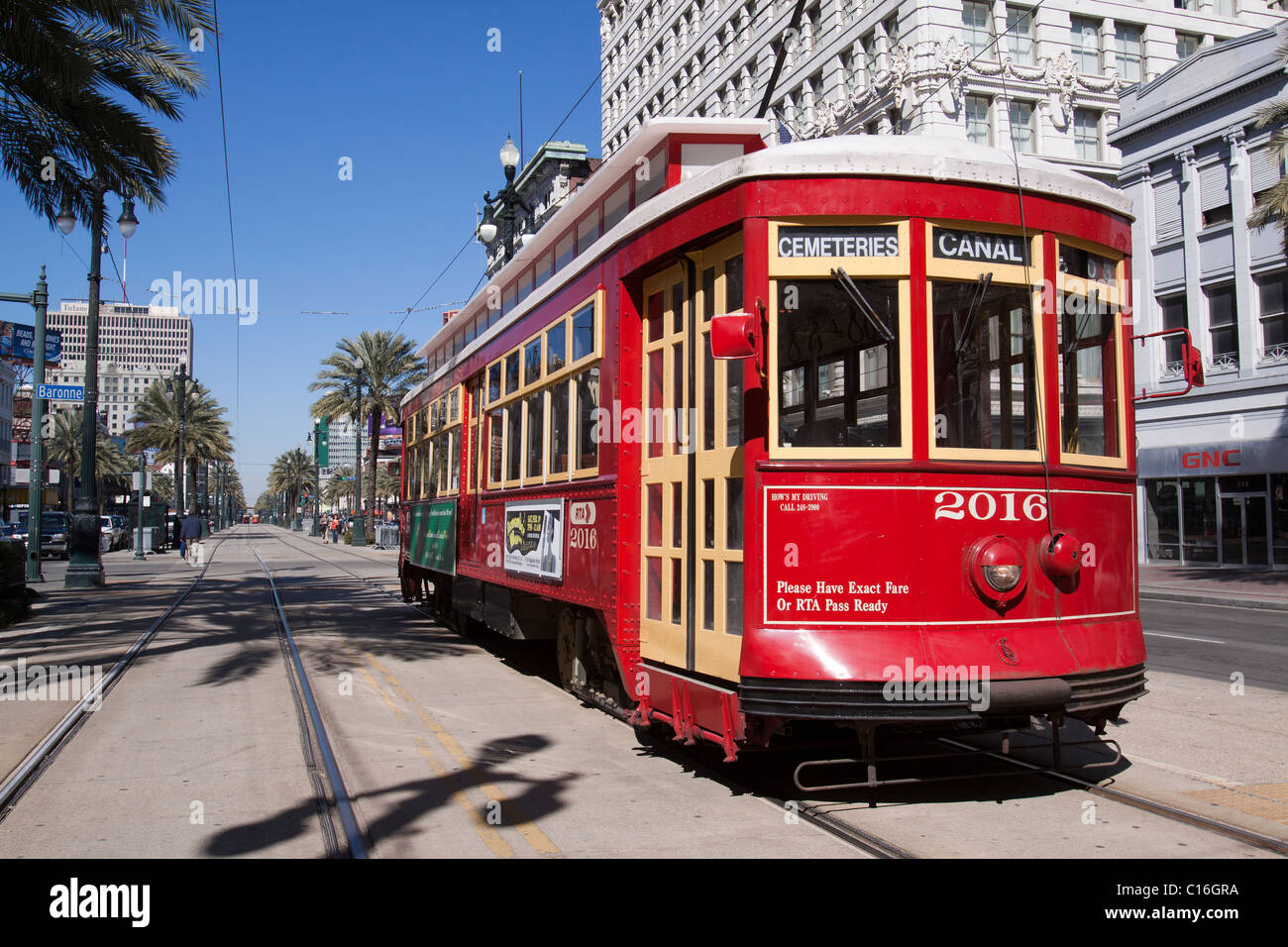 Red trolley car on the track on Canal Street in downtown New Orleans ...
