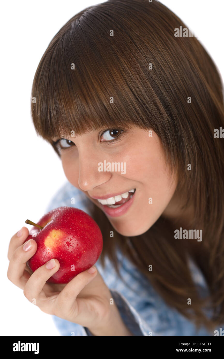 Happy teenager in pajamas eating healthy apple for breakfast on white ...