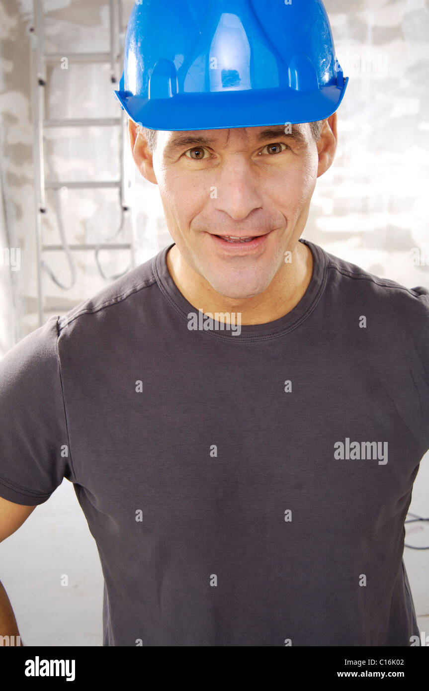 Smiling workman wearing a hard hat Stock Photo - Alamy