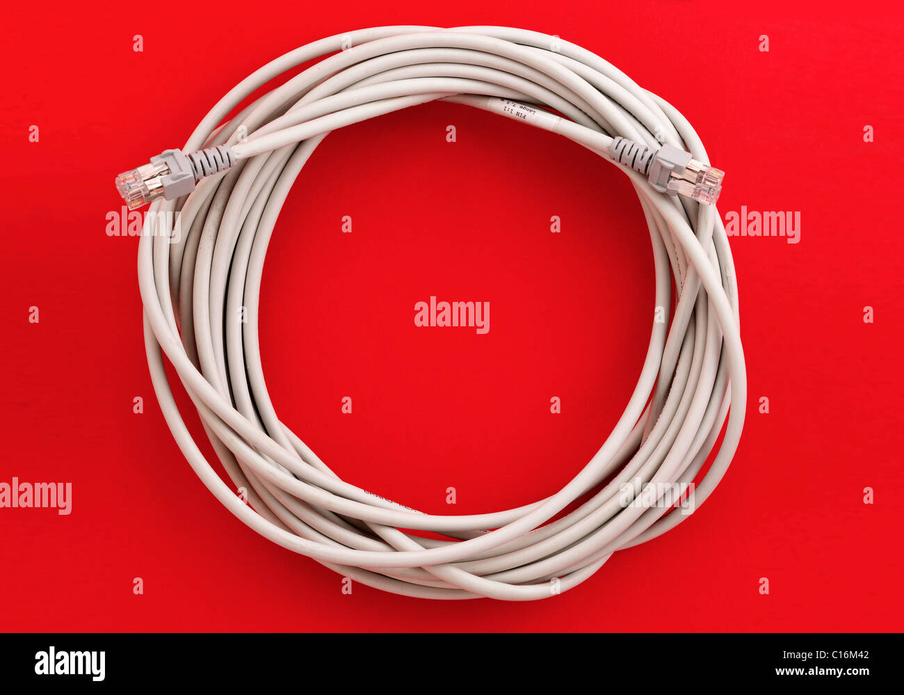 Used network cable on red surface Stock Photo - Alamy