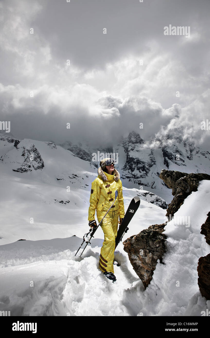 Skier standing in front of dramatic clouds, St. Moritz, Diavolezza ...
