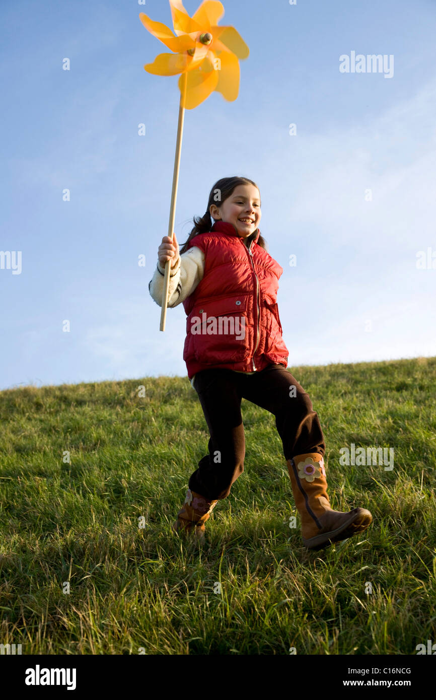 Girl running, holding a pinwheel in her hand Stock Photo - Alamy