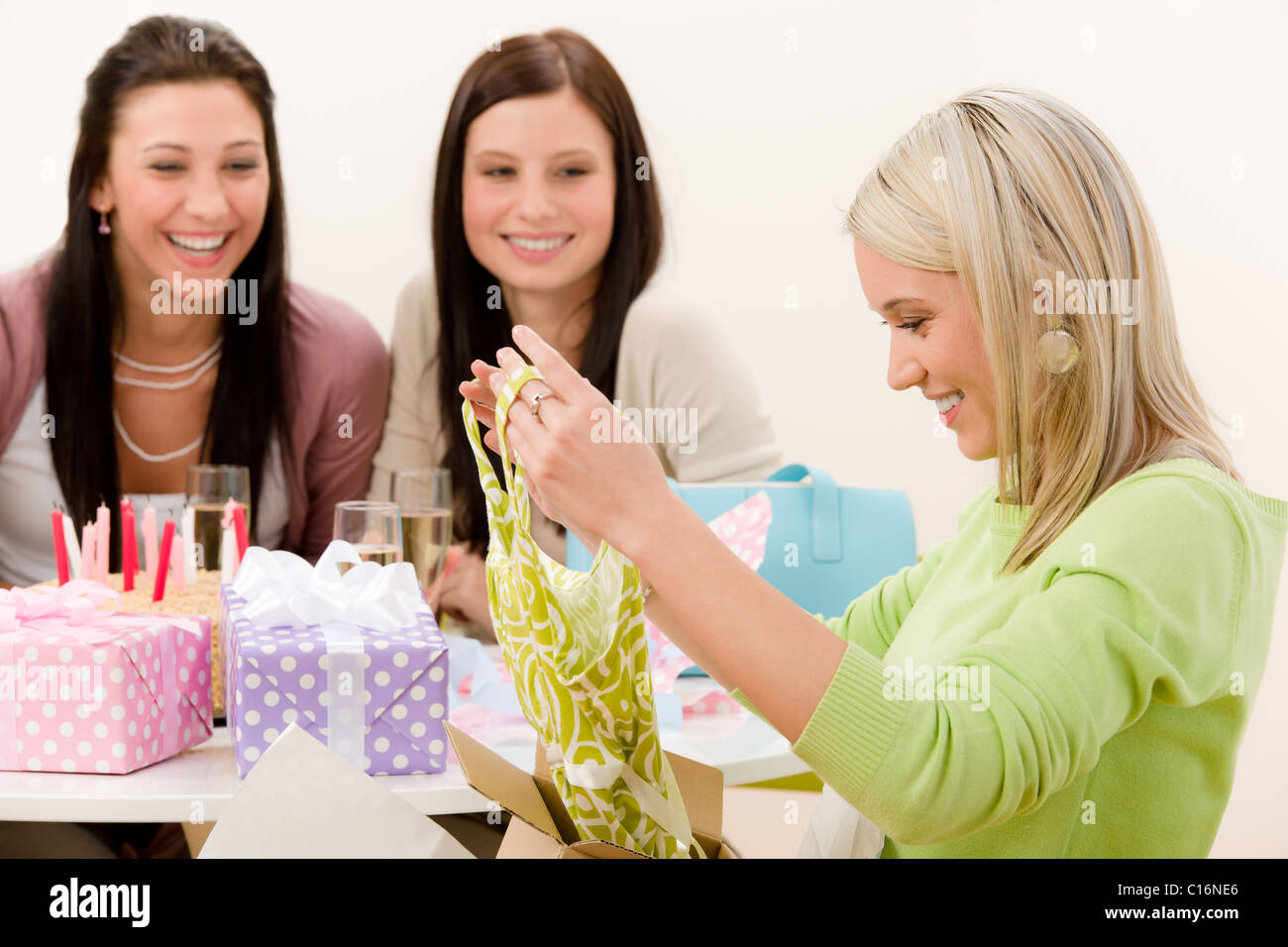 Birthday party - woman unwrap present, celebrating with champagne and ...