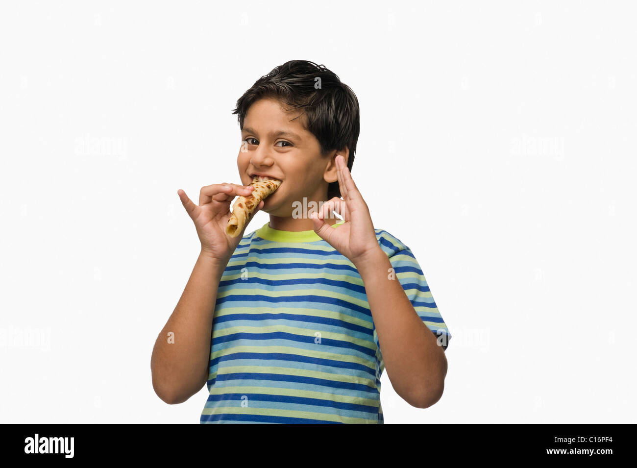 Boy eating bread and showing ok sign Stock Photo - Alamy
