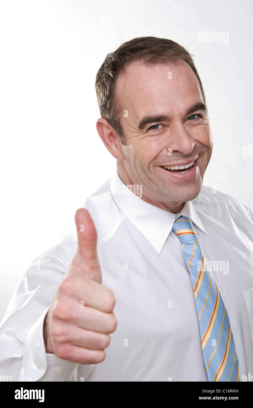 Laughing businessman indicating thumb up Stock Photo - Alamy