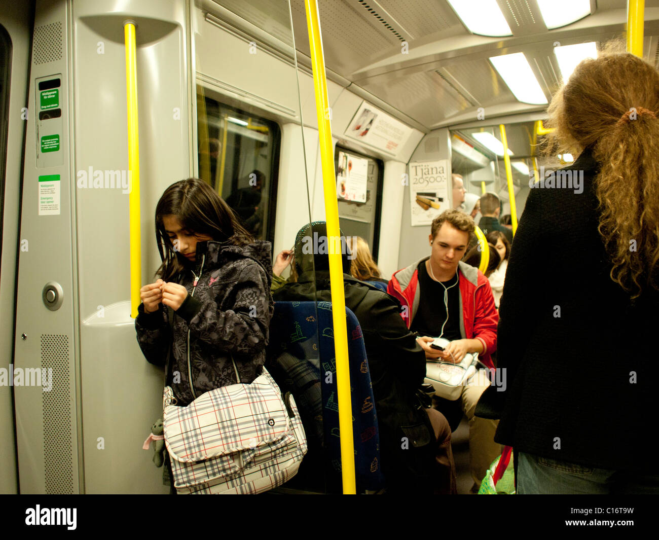 Bored commuter passengers listning to music on their portable ...