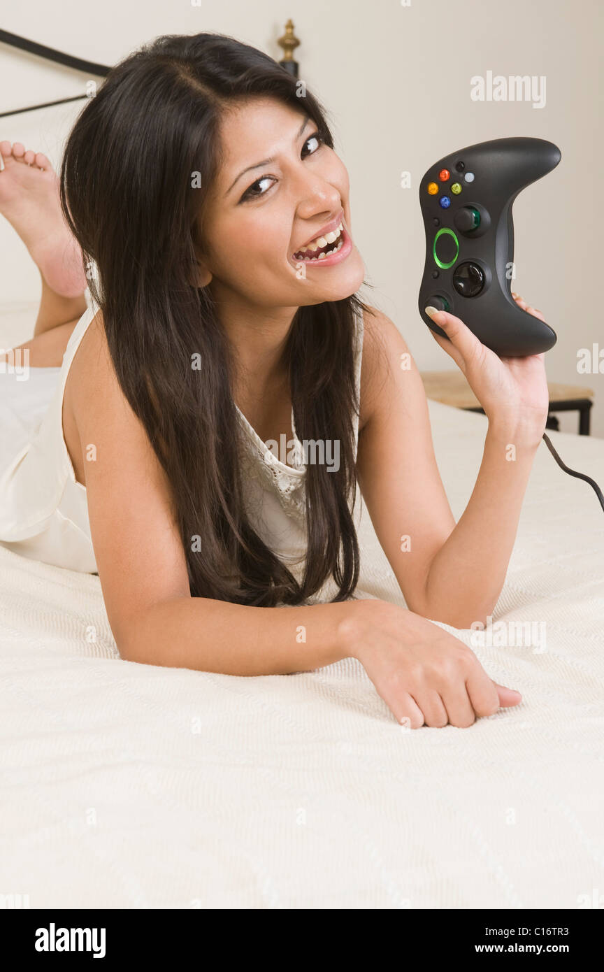 Woman playing a video game on the bed Stock Photo - Alamy