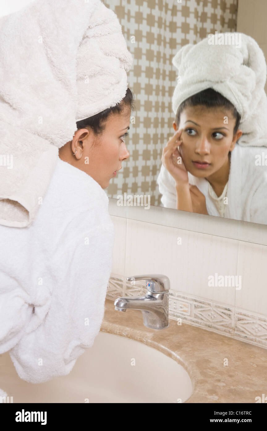 Woman looking into a mirror Stock Photo - Alamy