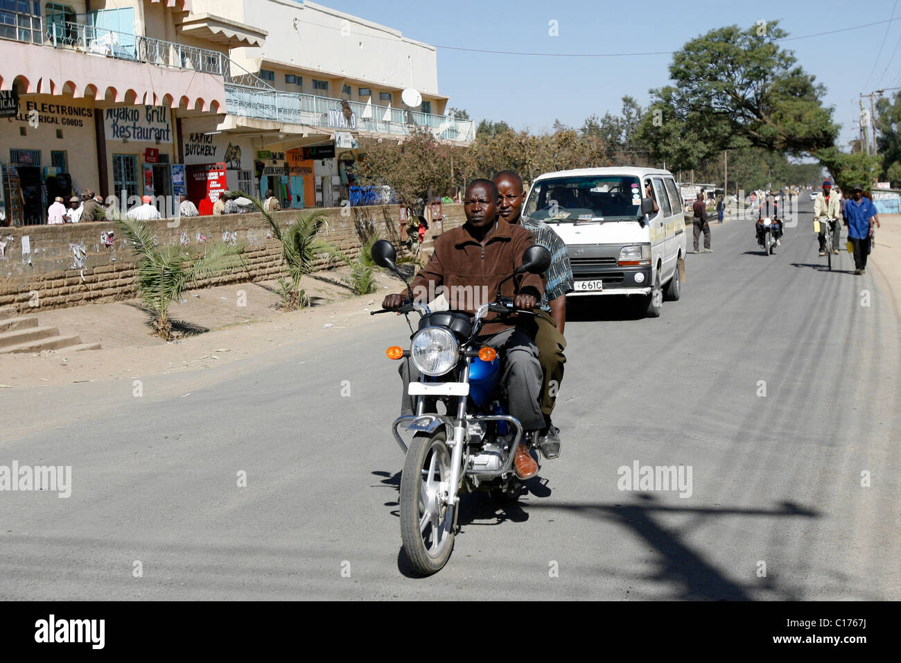 Two Kenyan men riding along a road on a motorbike Stock Photo - Alamy
