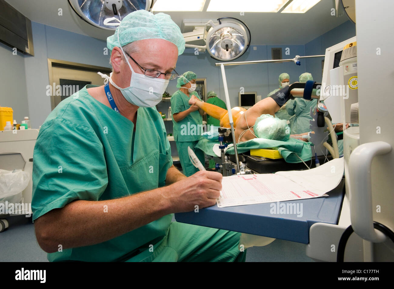Anaesthetist writing in the surgical protocol shortly before an ...