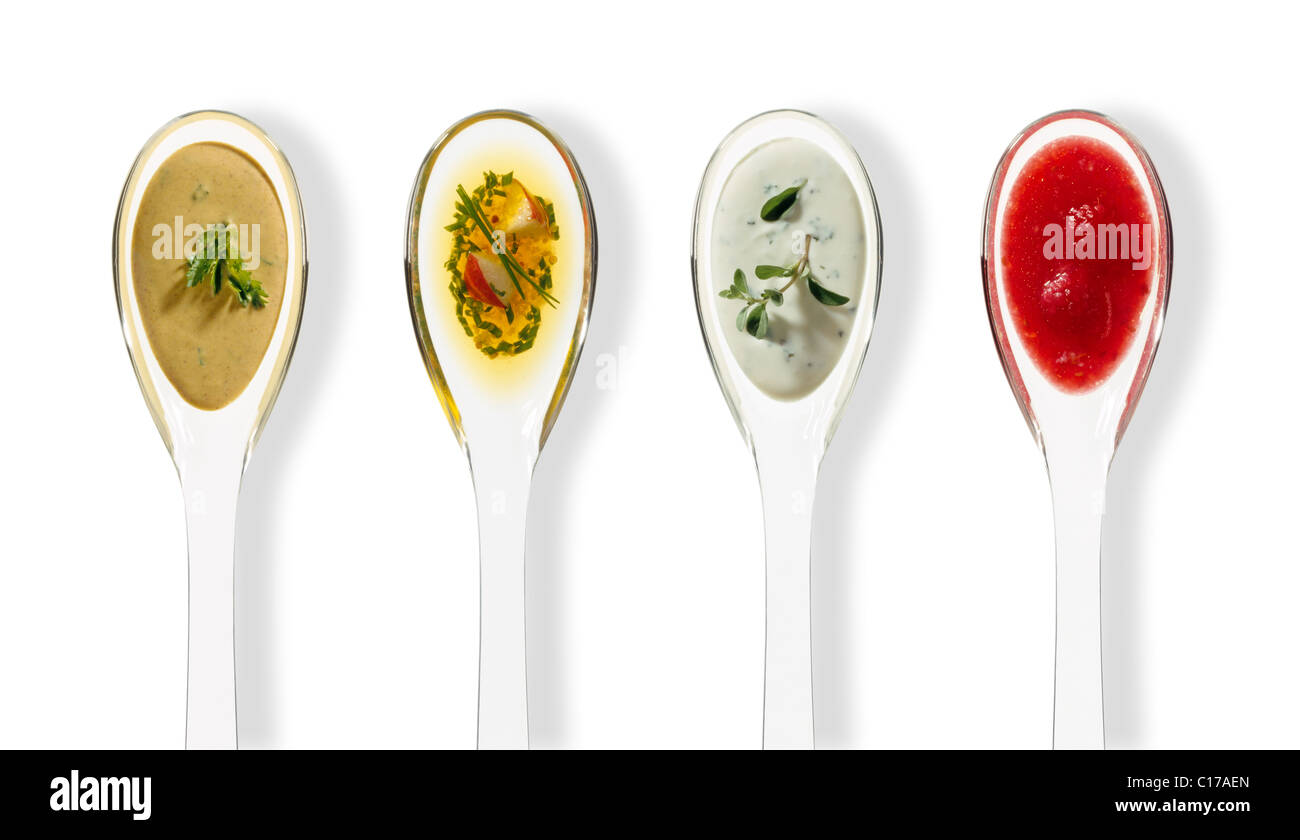 Four spoons with salad dressings Stock Photo - Alamy