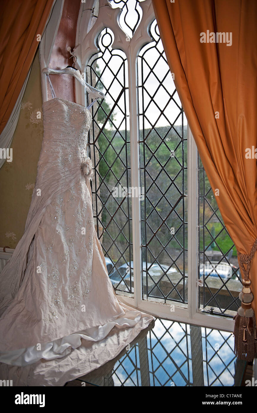 wedding dress hanging in window Stock Photo - Alamy