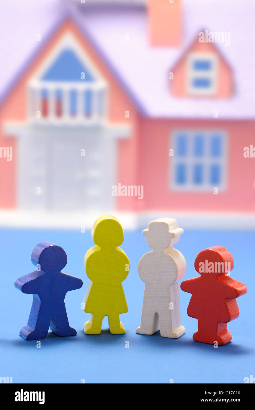 Wooden figures in front of a toy house model Stock Photo - Alamy
