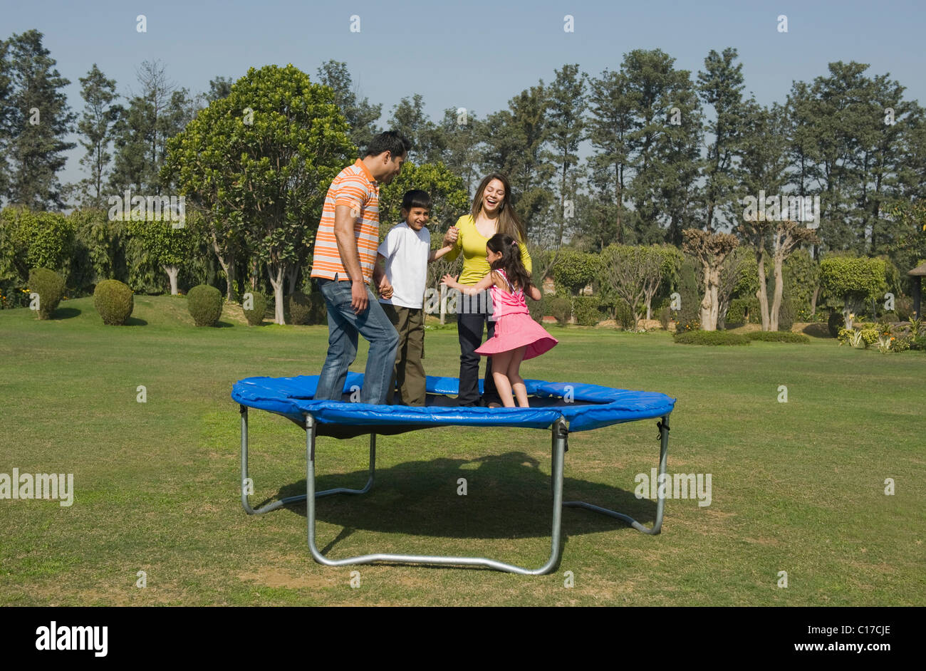 Family jumping on a trampoline Stock Photo - Alamy