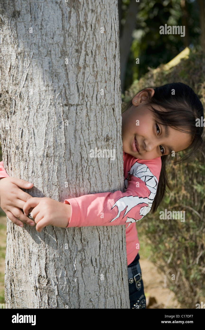 Girl hugging a tree and smiling Stock Photo - Alamy