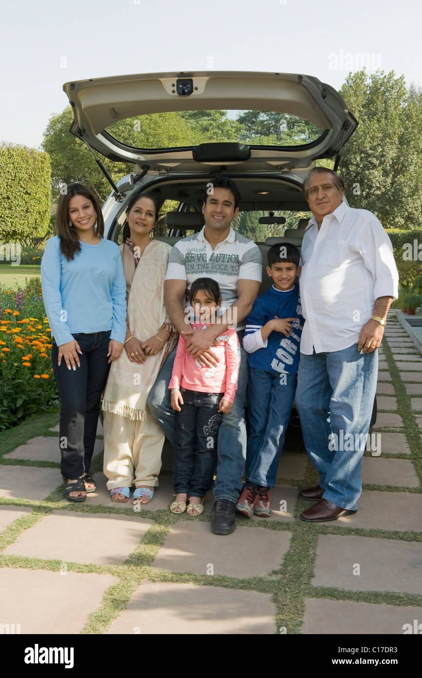 Family standing in front of a car Stock Photo - Alamy