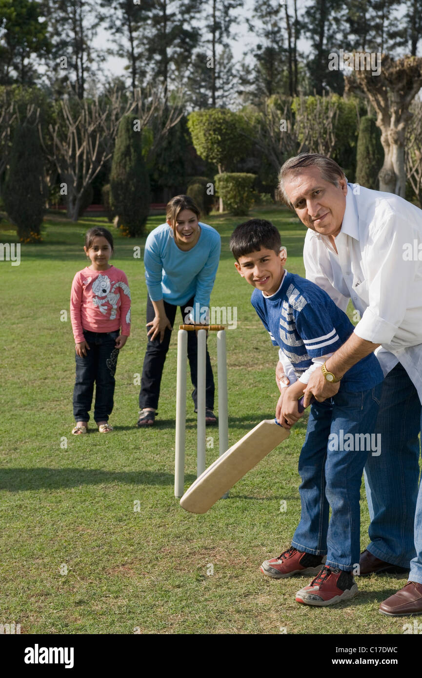 Family playing cricket in lawn Stock Photo - Alamy
