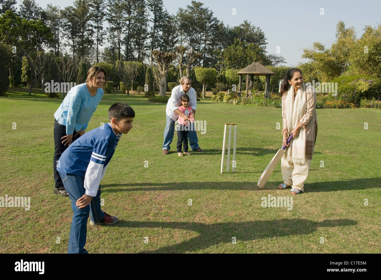 Family playing cricket in lawn Stock Photo - Alamy