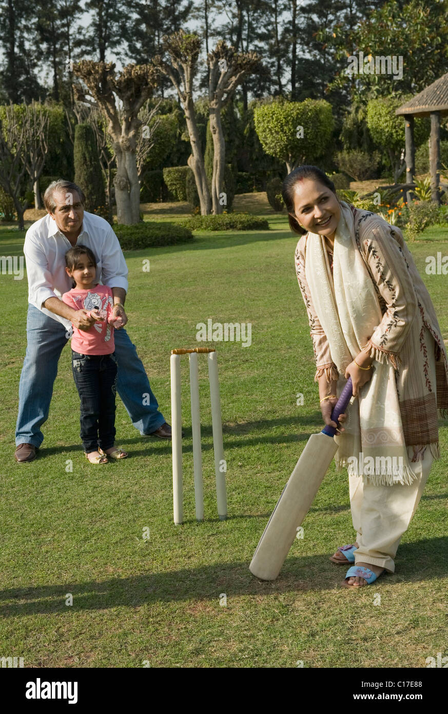 Family playing cricket in lawn Stock Photo - Alamy